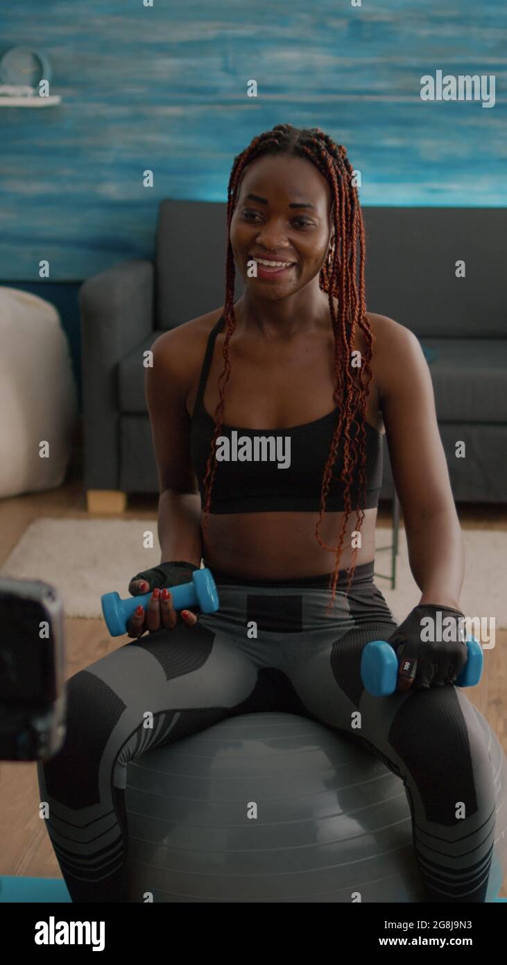 Black woman trainer practicing morning yoga exercise sitting on fitness ...