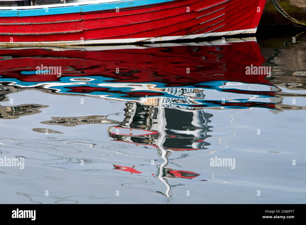 Reflection of old red boat in a small harbour location Stock Photo - Alamy