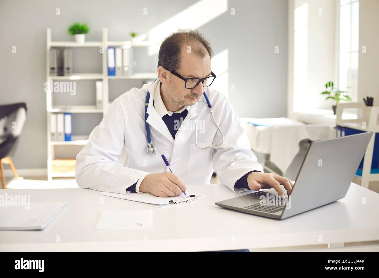 Doctor writing notes desk hi-res stock photography and images - Alamy