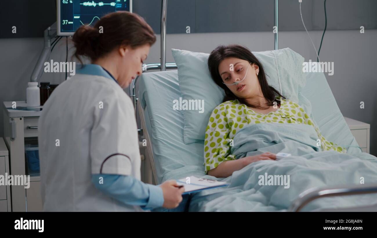 Doctor practitioner writing sickness symptom on clipboard checking ...