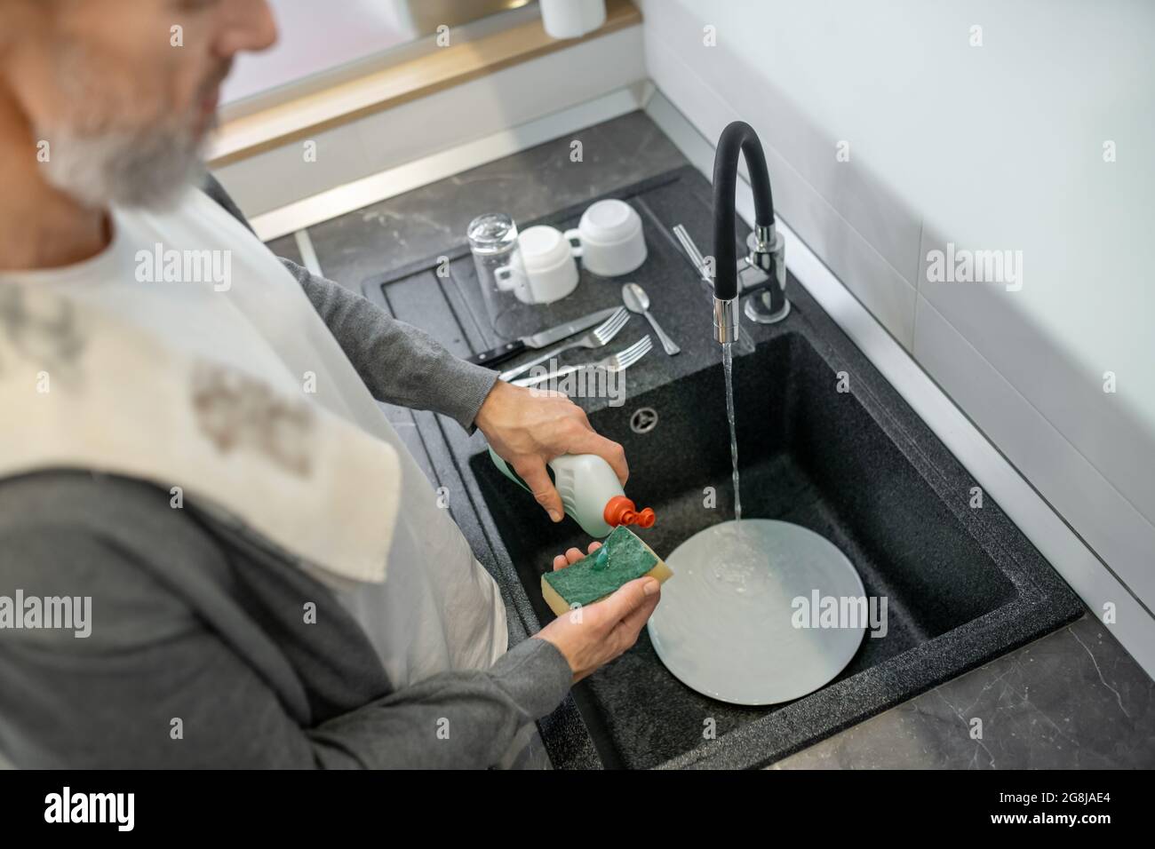 Close up of a man washing the plates in the kitchen Stock Photo - Alamy