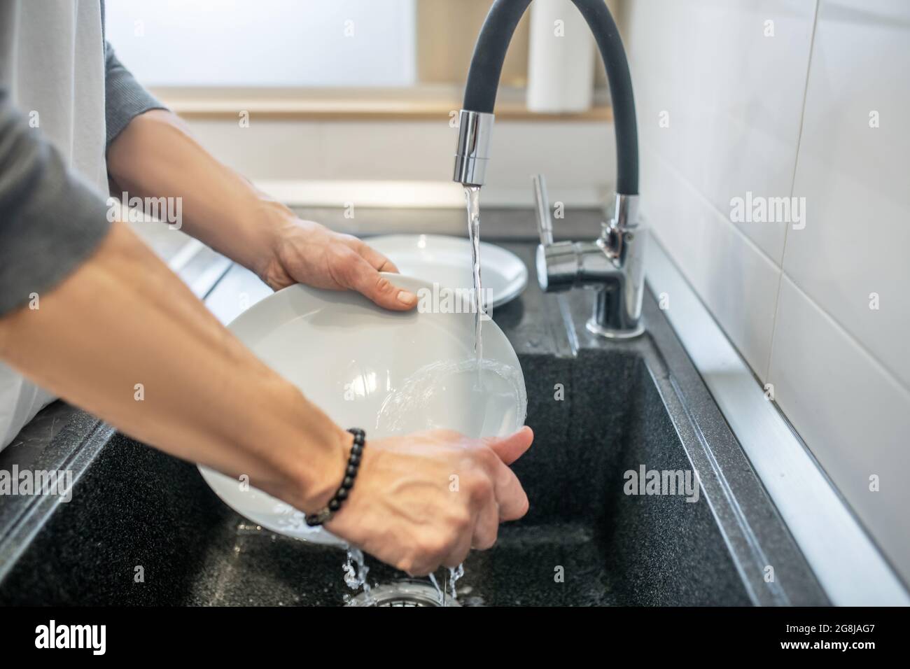 Close up of a man washing the plates in the kitchen Stock Photo - Alamy