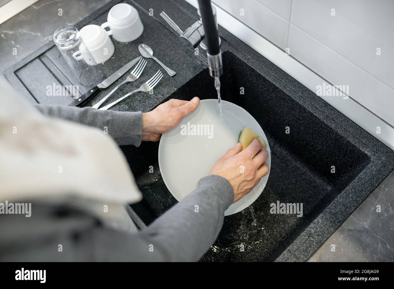 Close up of a man washing the plates in the kitchen Stock Photo - Alamy