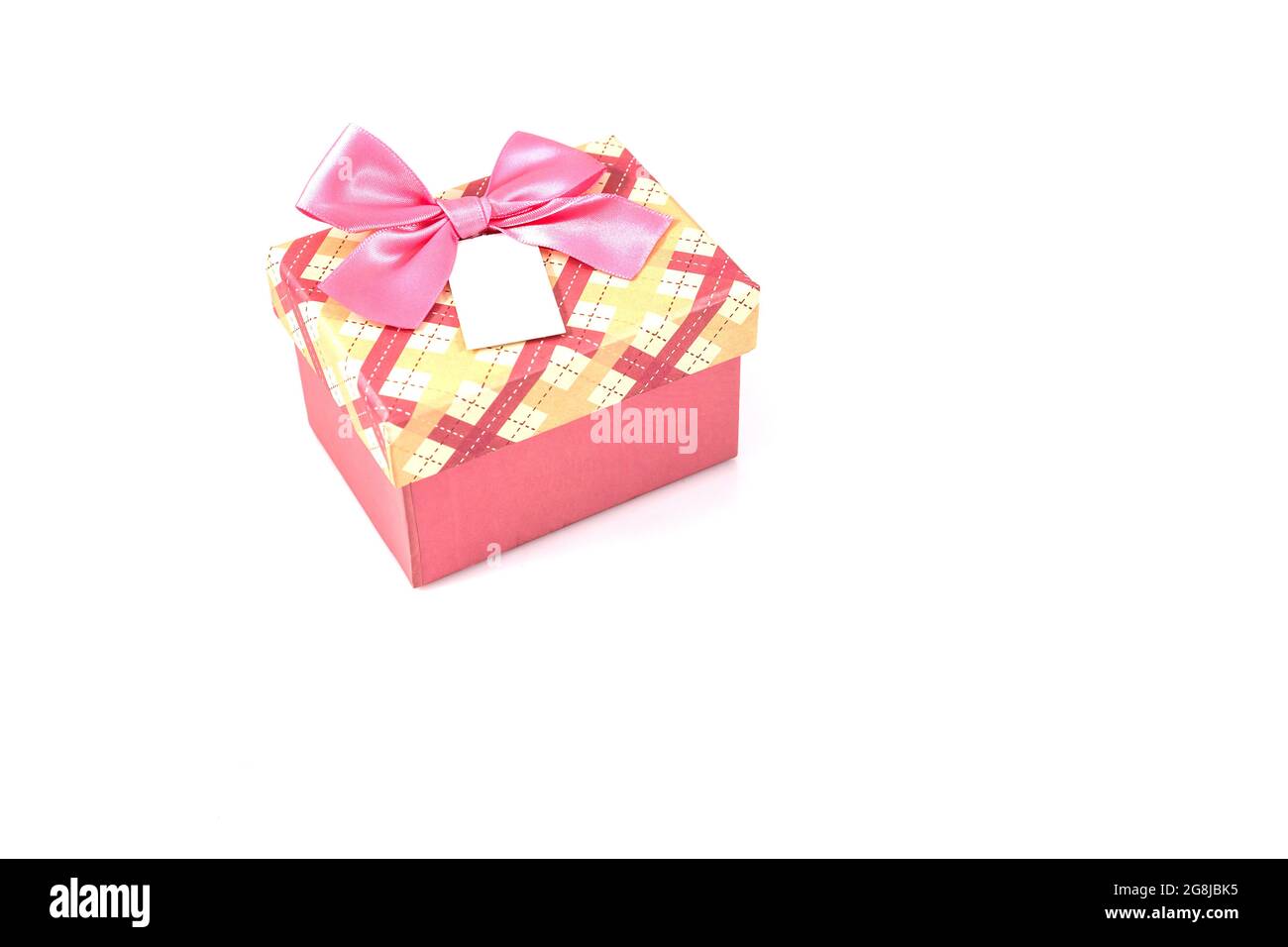 Pink Christmas gift box with pink bow and white tag isolated on white ...
