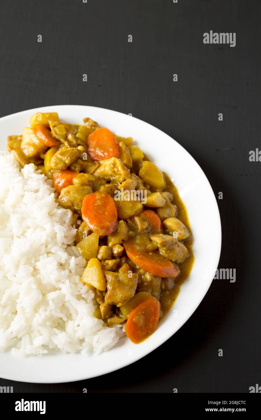 Homemade Japanese Chicken Curry on a white plate on a black background ...