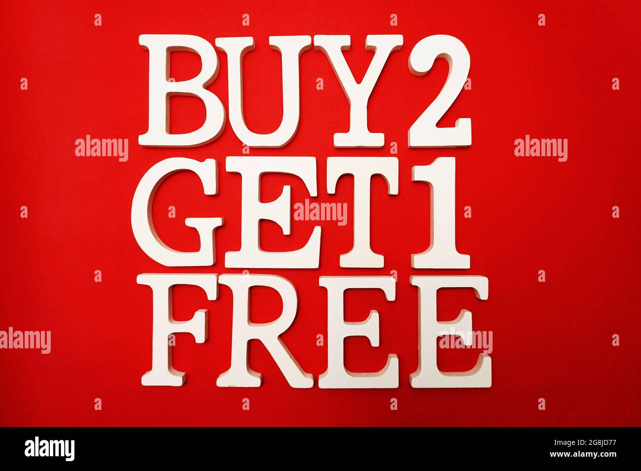 BUY 2 GET 1 FREE alphabet letters on red background Stock Photo - Alamy
