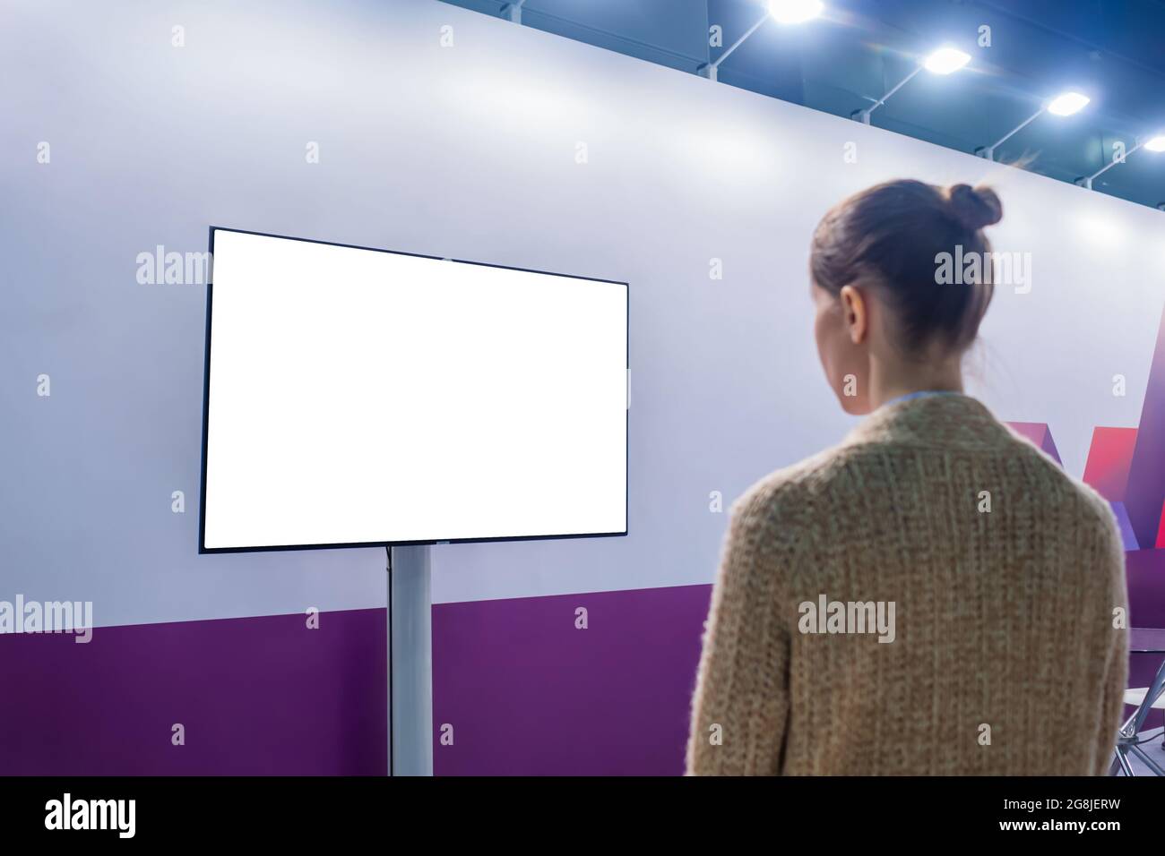 Woman looking at blank white display wall at exhibition - white screen ...