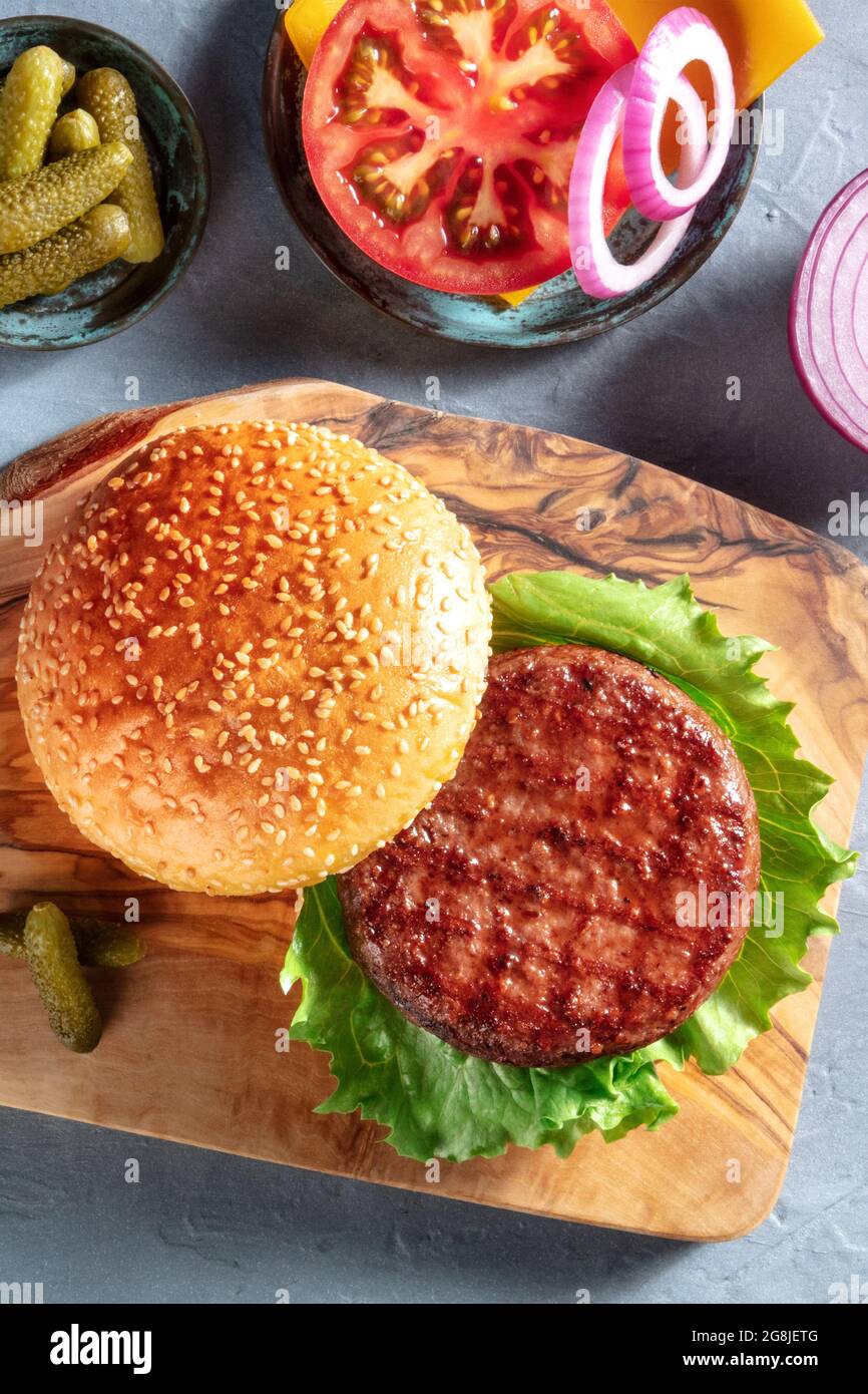 Burger ingredients close-up with a beef patty, green salad leaf, and ...