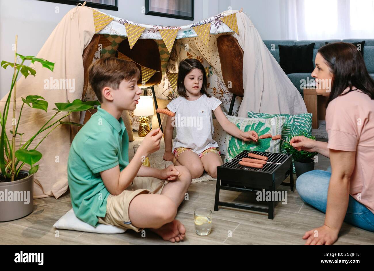 Family grilling and eating sausages on barbecue Stock Photo - Alamy