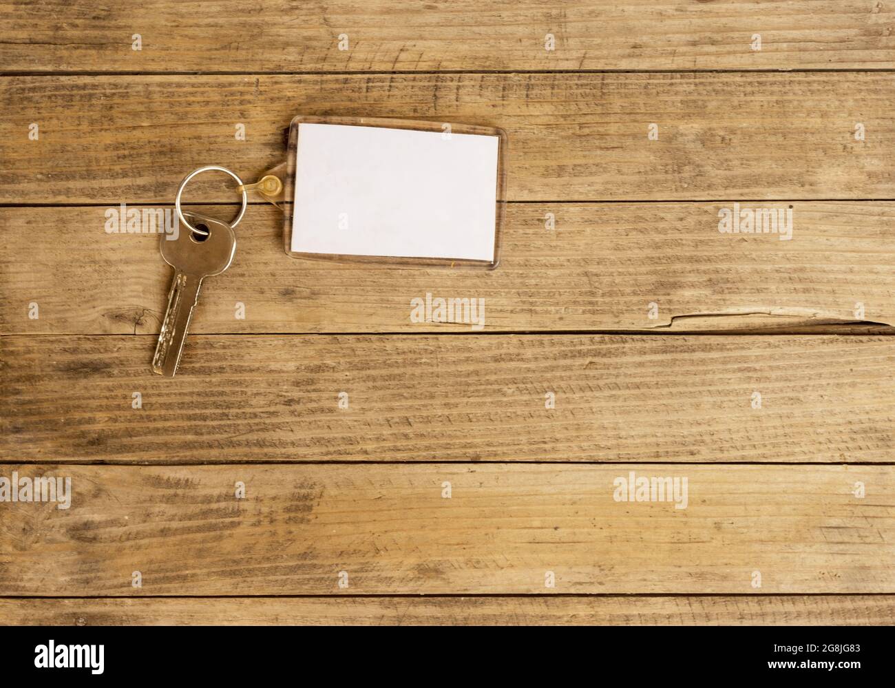 Top view of a key with a keychain on wooden background Stock Photo - Alamy