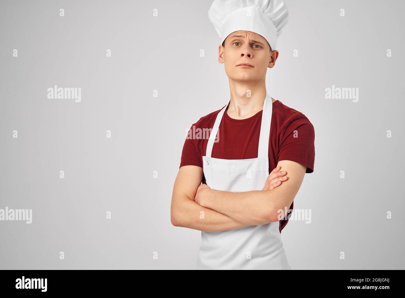 man chef aprons with a cap on his head light background Professional ...