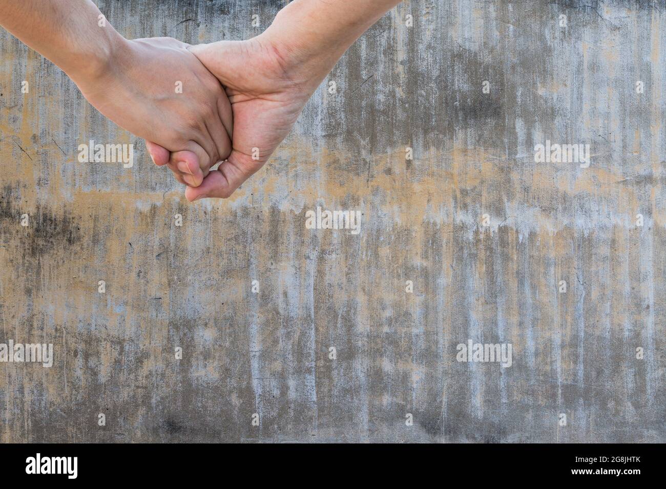 Lover hold hand on aged vintage gray cement wall texture background ...