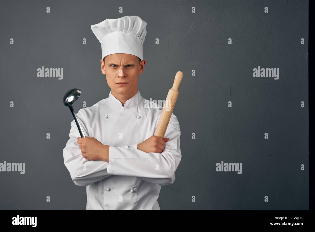 cook in uniform kitchen items serious look Professional Stock Photo - Alamy