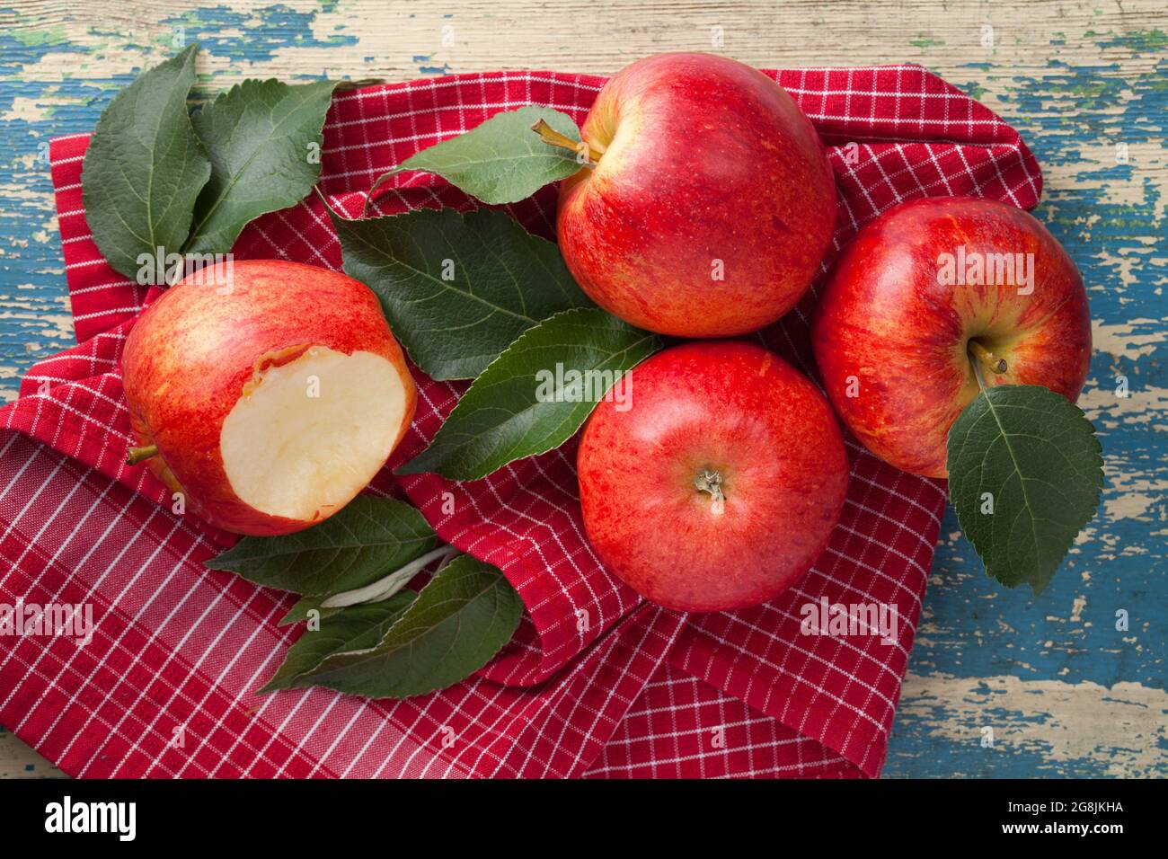 Red gala apples composition with fresh green leaves on red and white ...