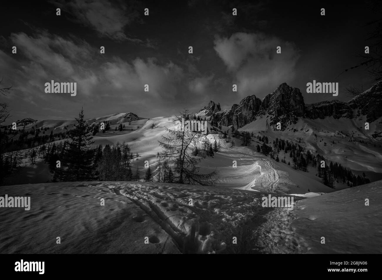 Black and view of path in the snow with human traces that leads to ...