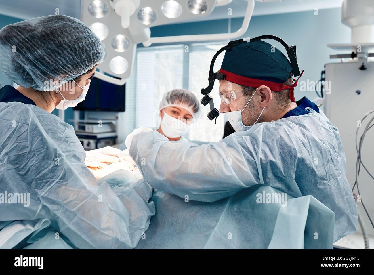 A team of women and men surgeons doing complex heart surgery ...