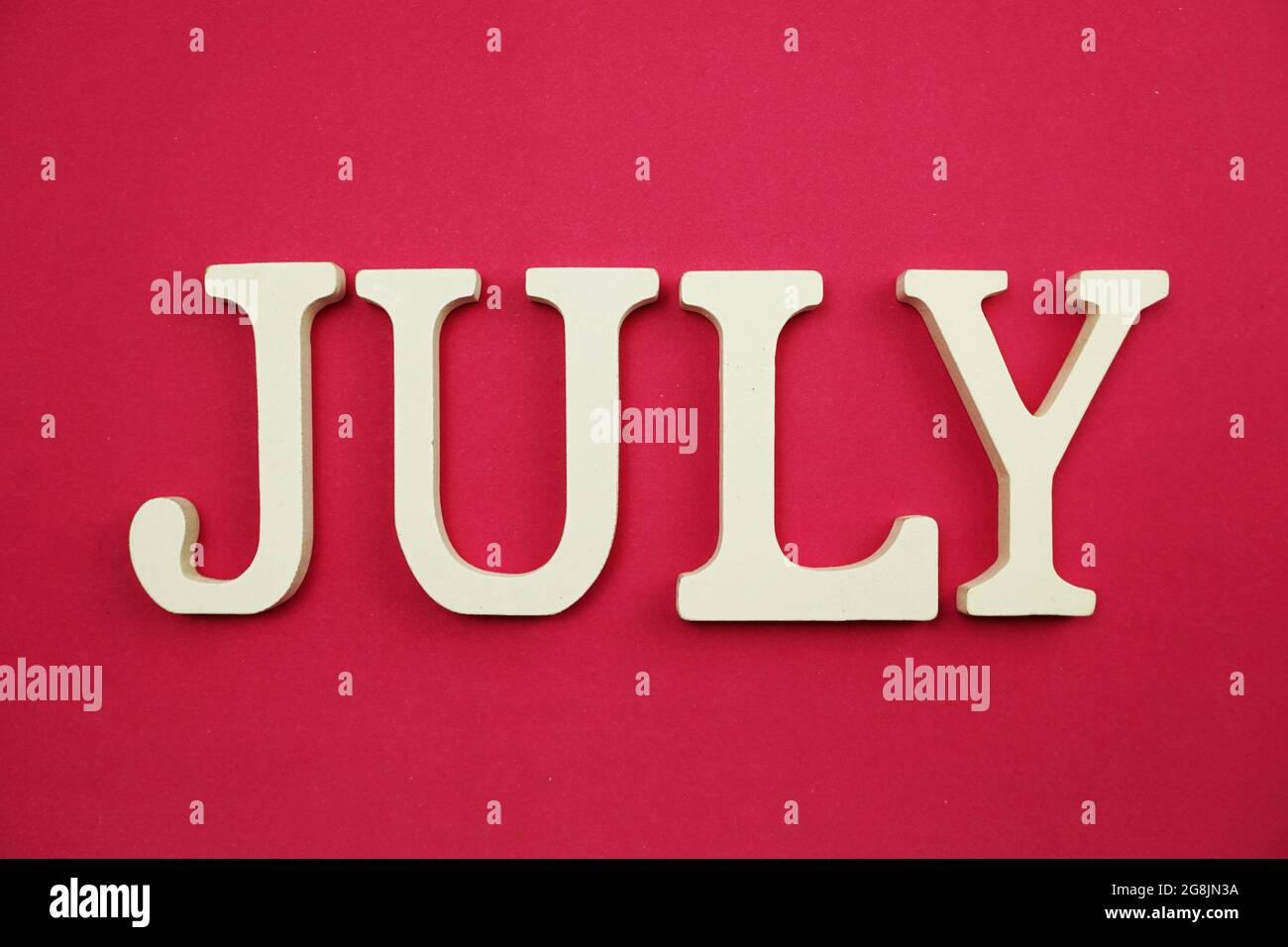 July alphabet letter with space copy on pink background Stock Photo - Alamy