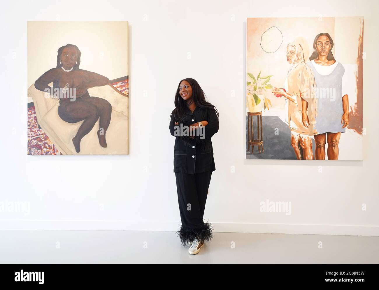 Curator Adora Mba stands between 'Woman with Pearls Resting' (left) by ...