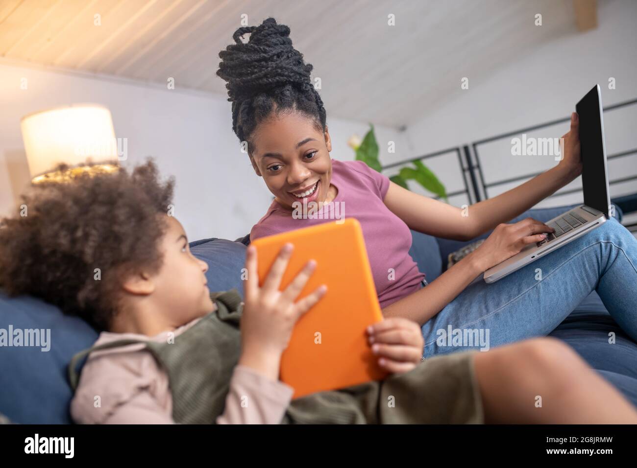 Little girl showing tablet to joyful mom Stock Photo - Alamy
