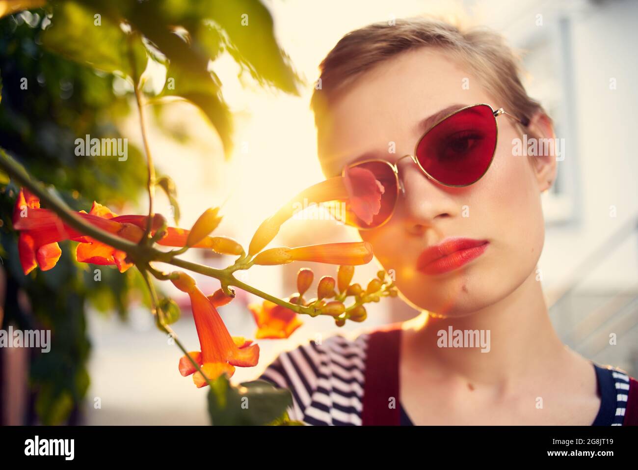 pretty woman wearing sunglasses bush with flowers outdoors Stock Photo ...