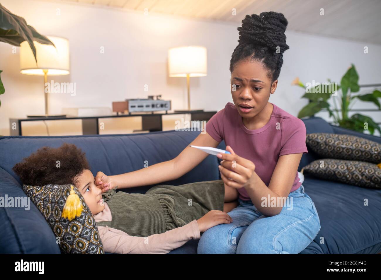 Shocked mom with thermometer and lying little girl Stock Photo - Alamy