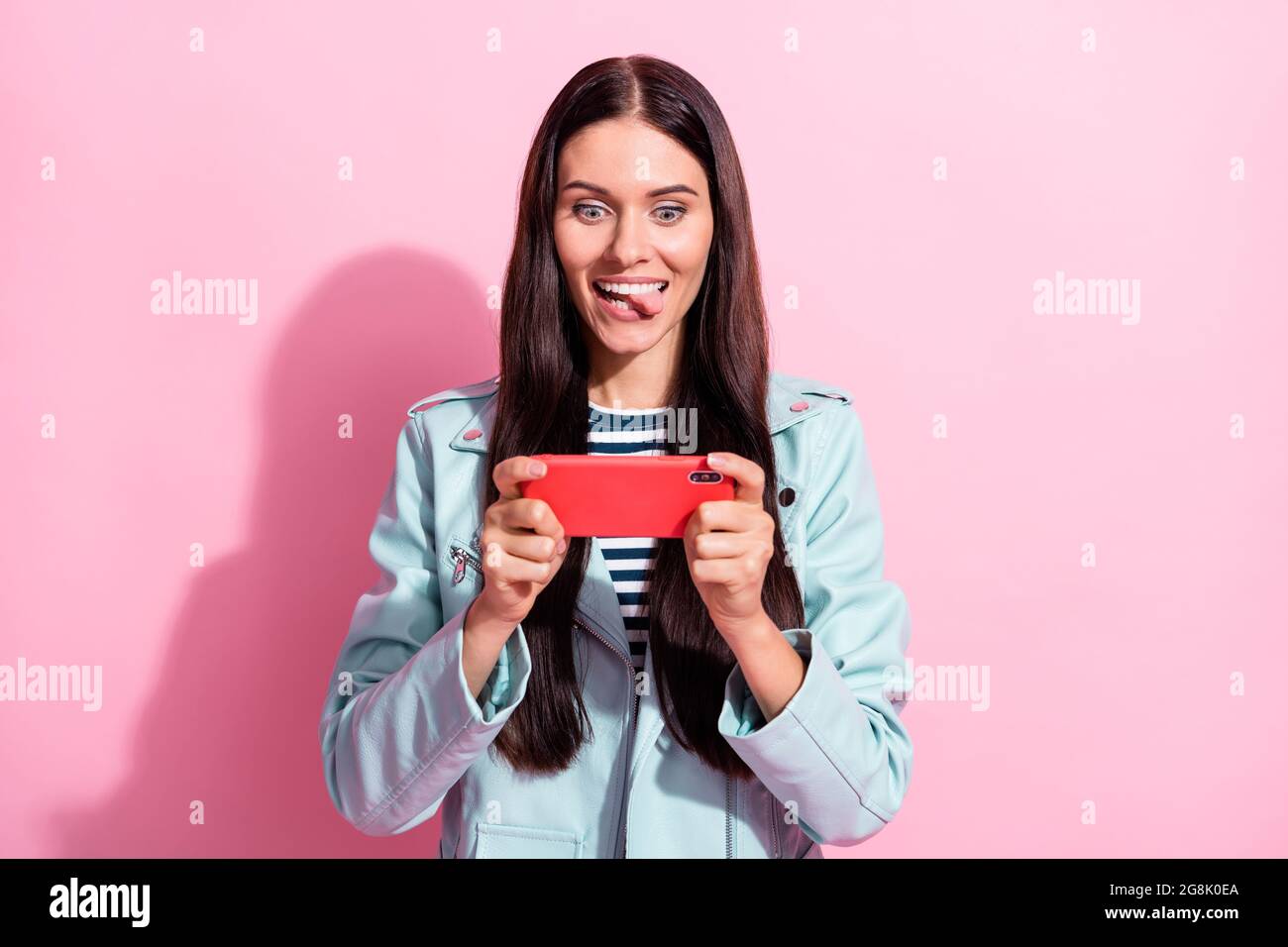 Photo of crazy playful young woman hold phone stick out tongue gamer ...