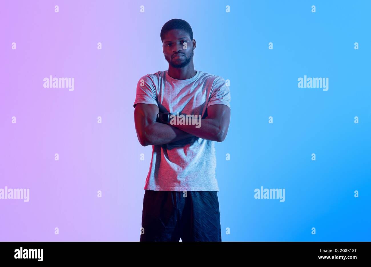 Black male fitness model standing with crossed arms, looking at camera ...