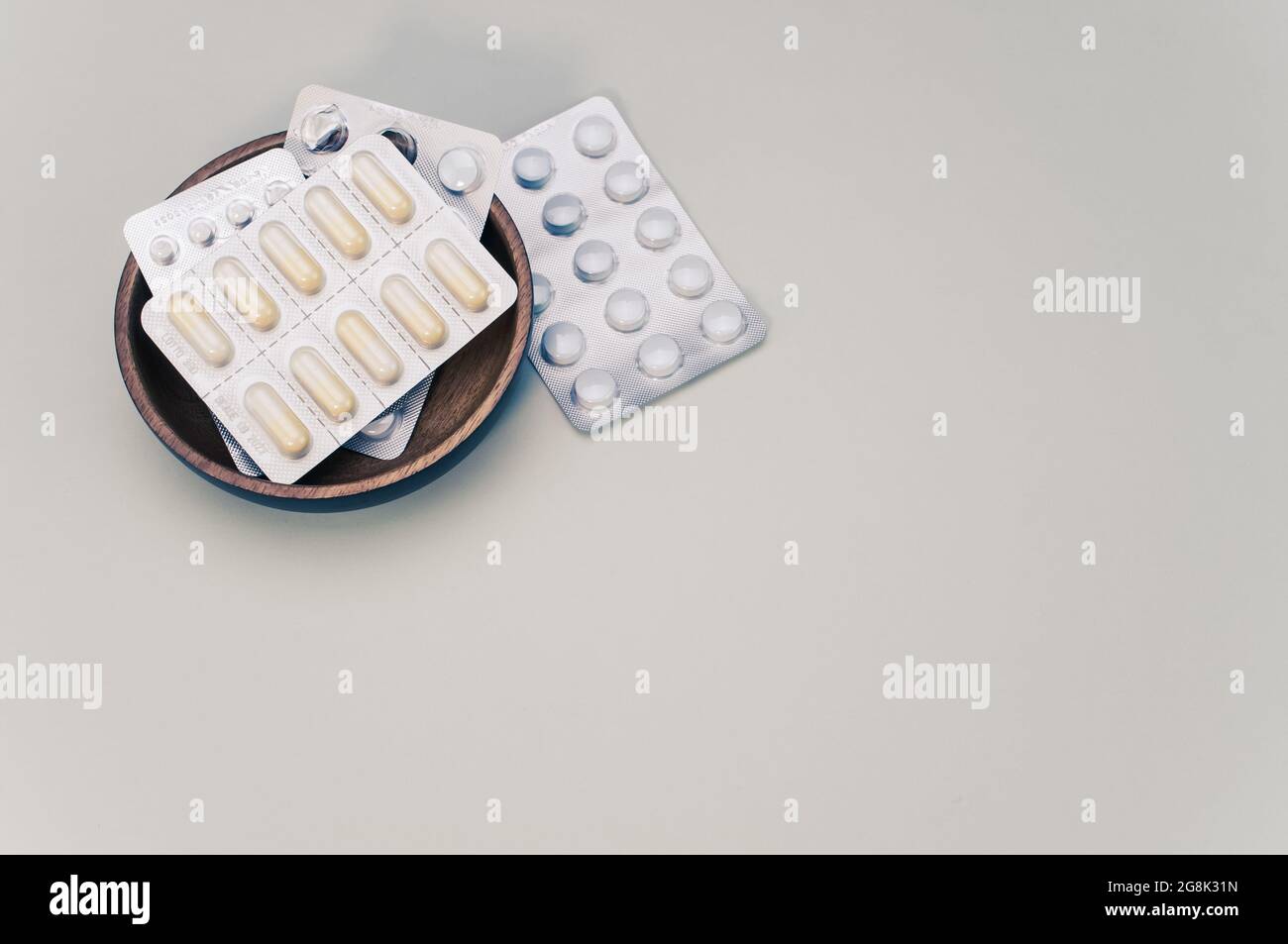 Group of pill blister packs in a bowl isolated on a beige background ...