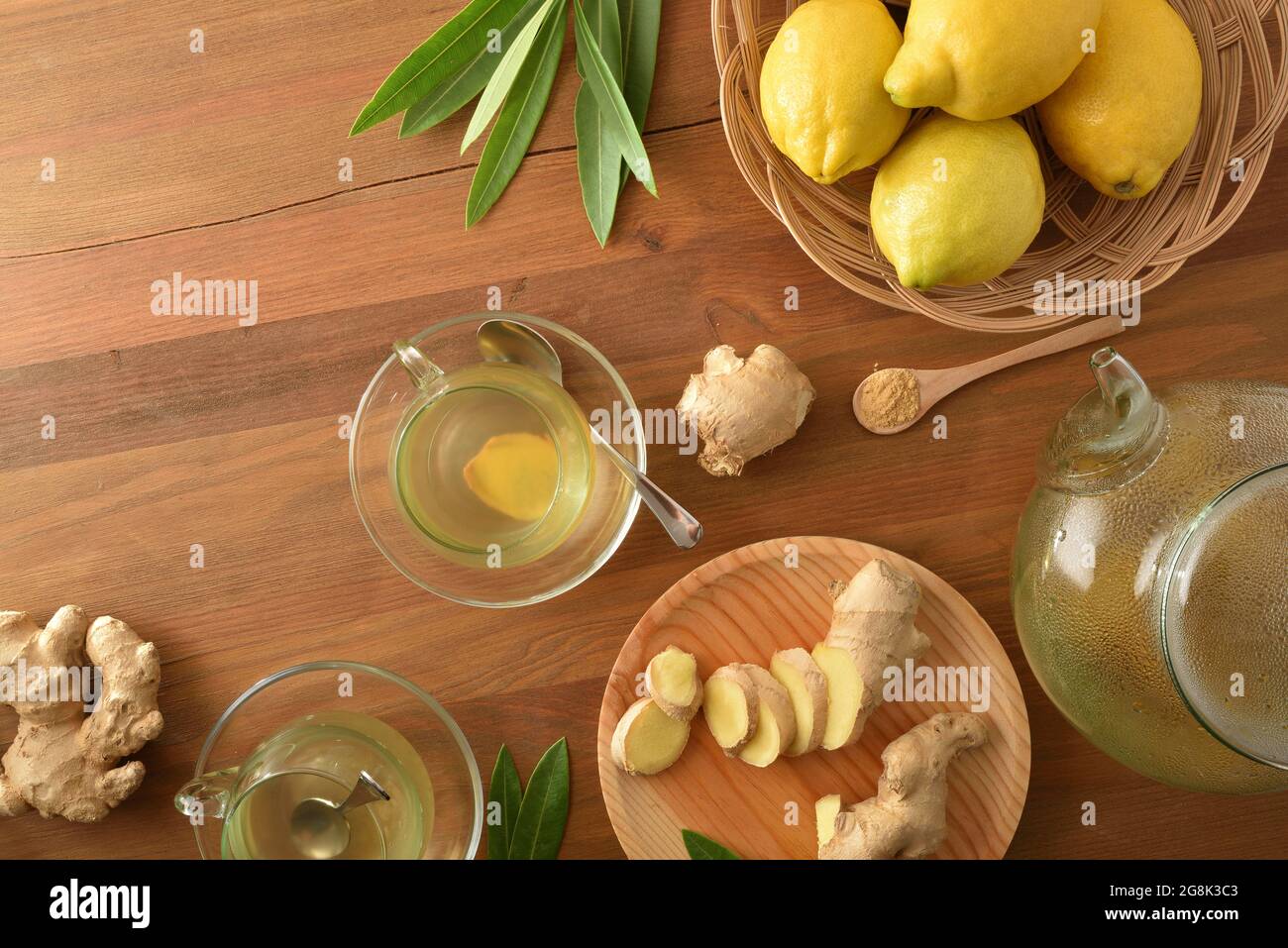 Ginger infusion on wooden table with sliced ginger root and teapot. Top ...