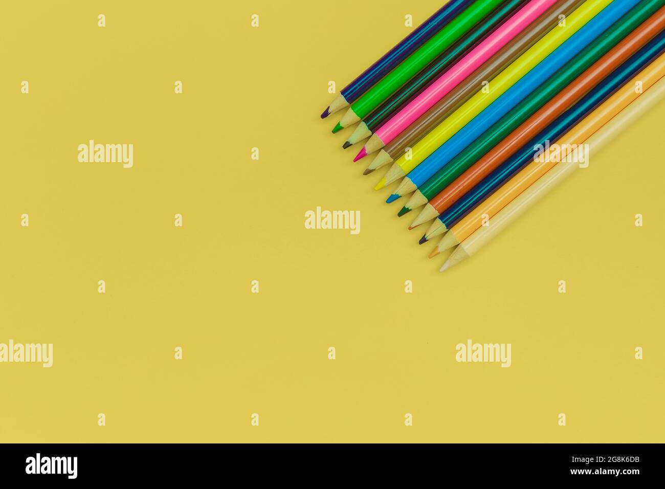 colored pencils on a yellow background Stock Photo - Alamy