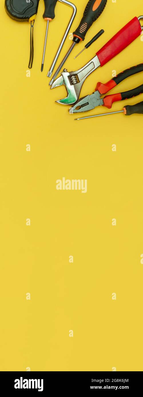 tools on isolated yellow background panorama Stock Photo - Alamy