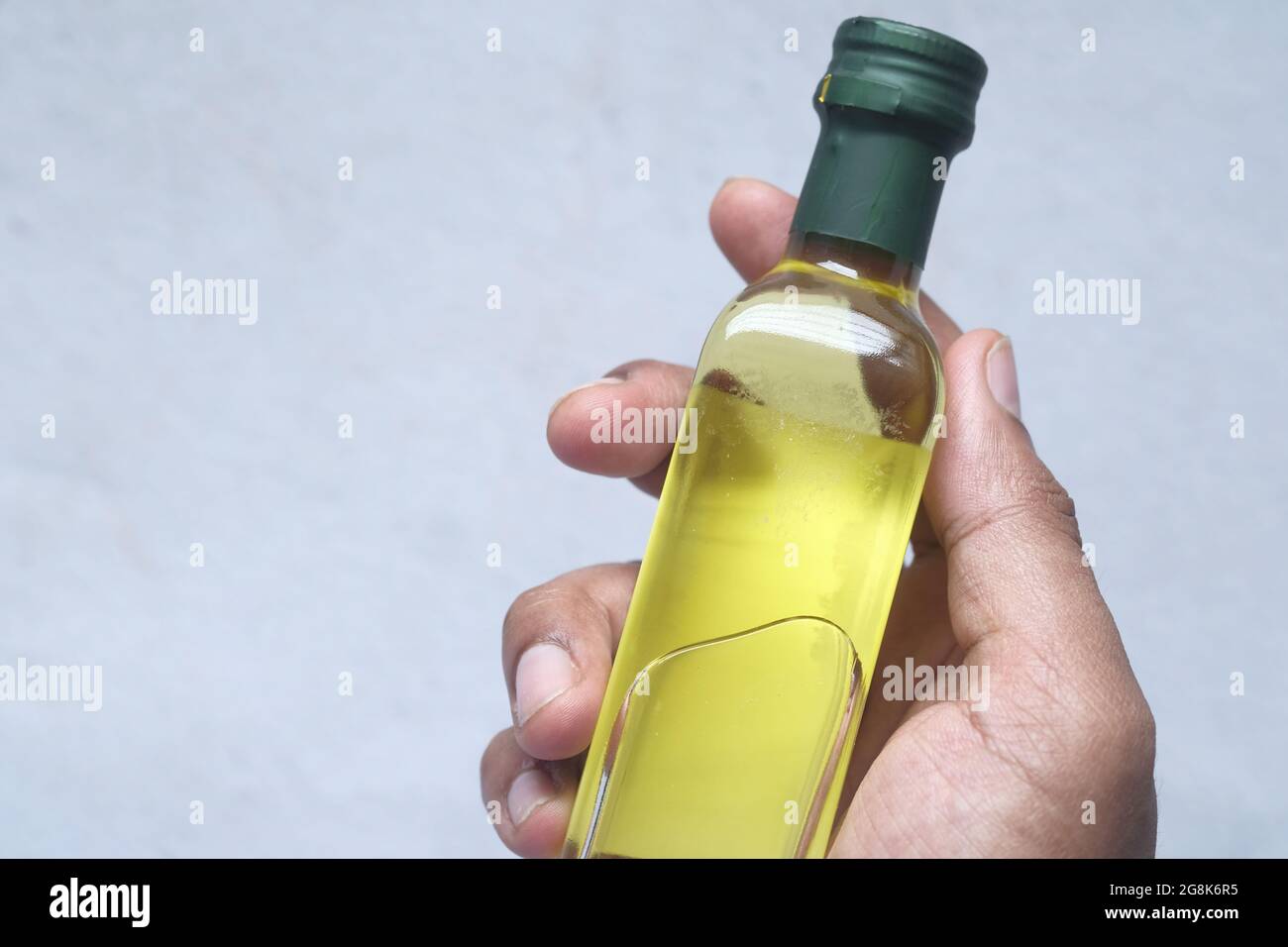 hand holding a bottle of olive oil Stock Photo - Alamy