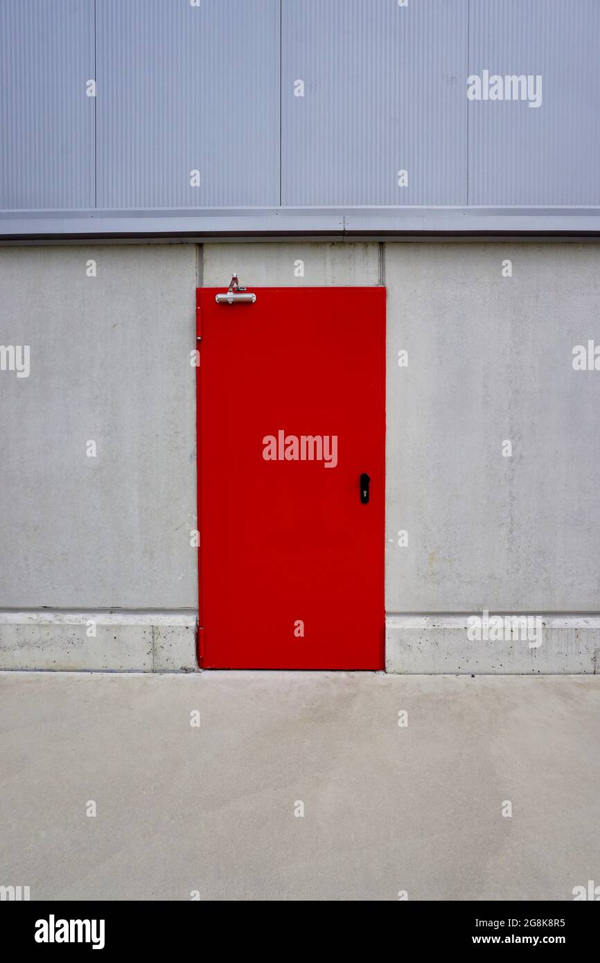 Vertical of a metallic red-painted door of a factory Stock Photo - Alamy