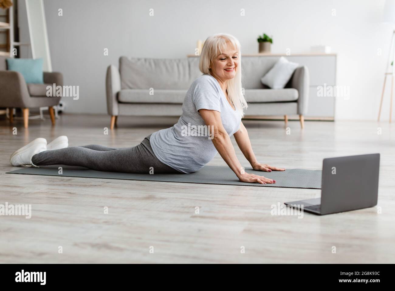 Mature woman stretching back on mat, cobra pose Stock Photo - Alamy