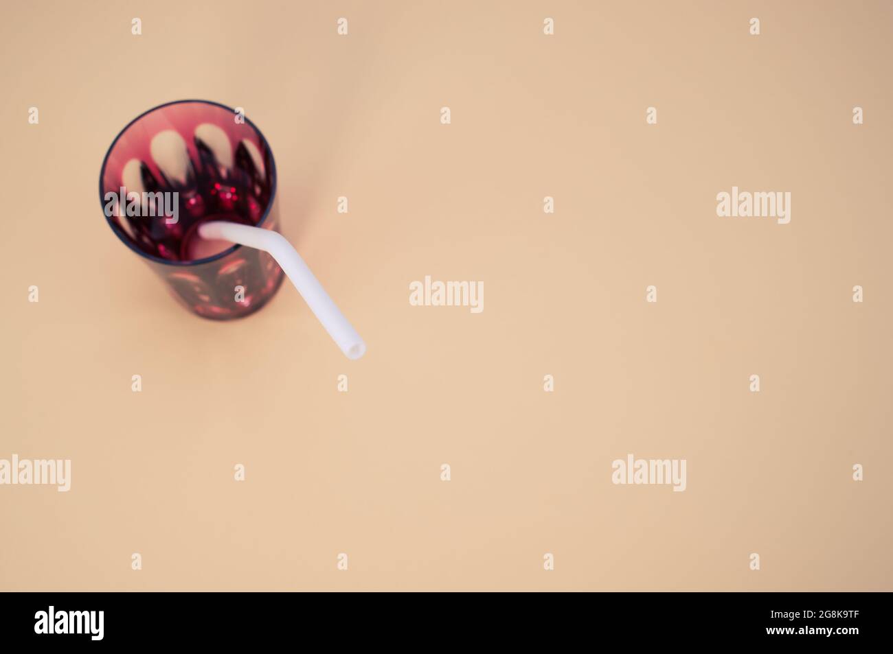 Drinking straw in a glass cup isolated on a beige background Stock ...