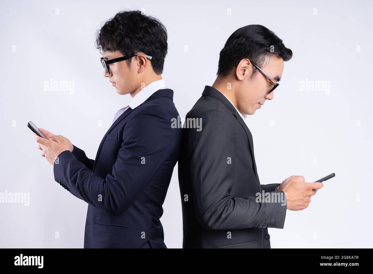 Young Vietnamese male employees in suits standing back to back and ...