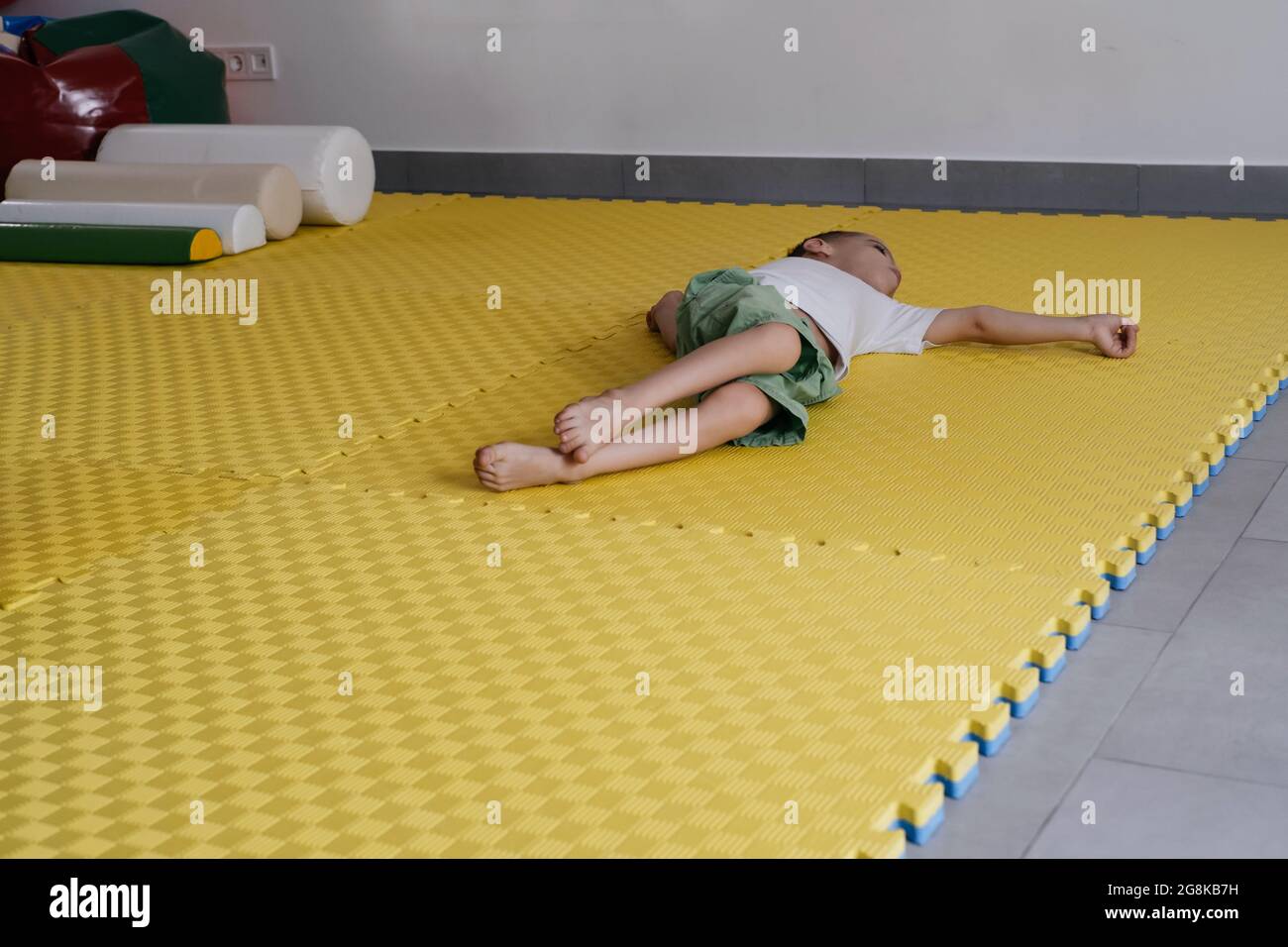 Child on the mat in child rehabilitation center. Boy with cerebral ...
