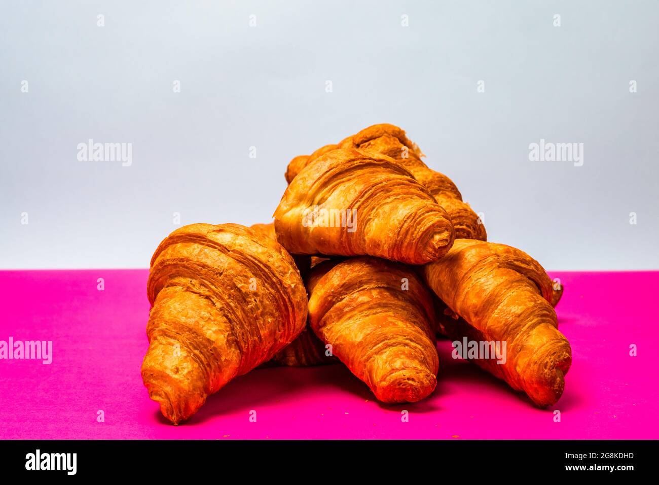 Freshly baked croissants isolated on pink and white background Stock ...