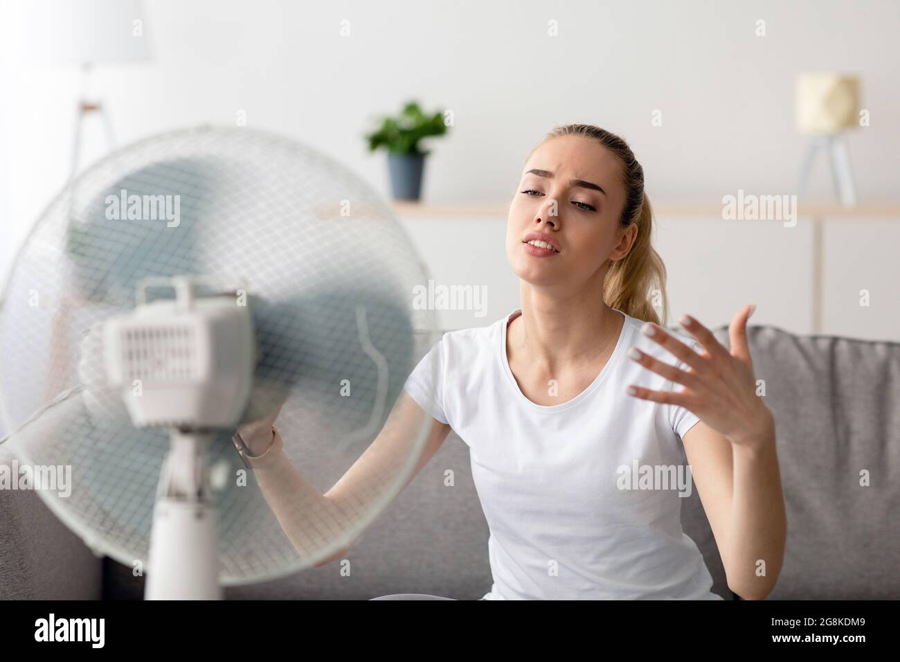 Mature woman cooling herself in front of fan during hot weather Stock ...