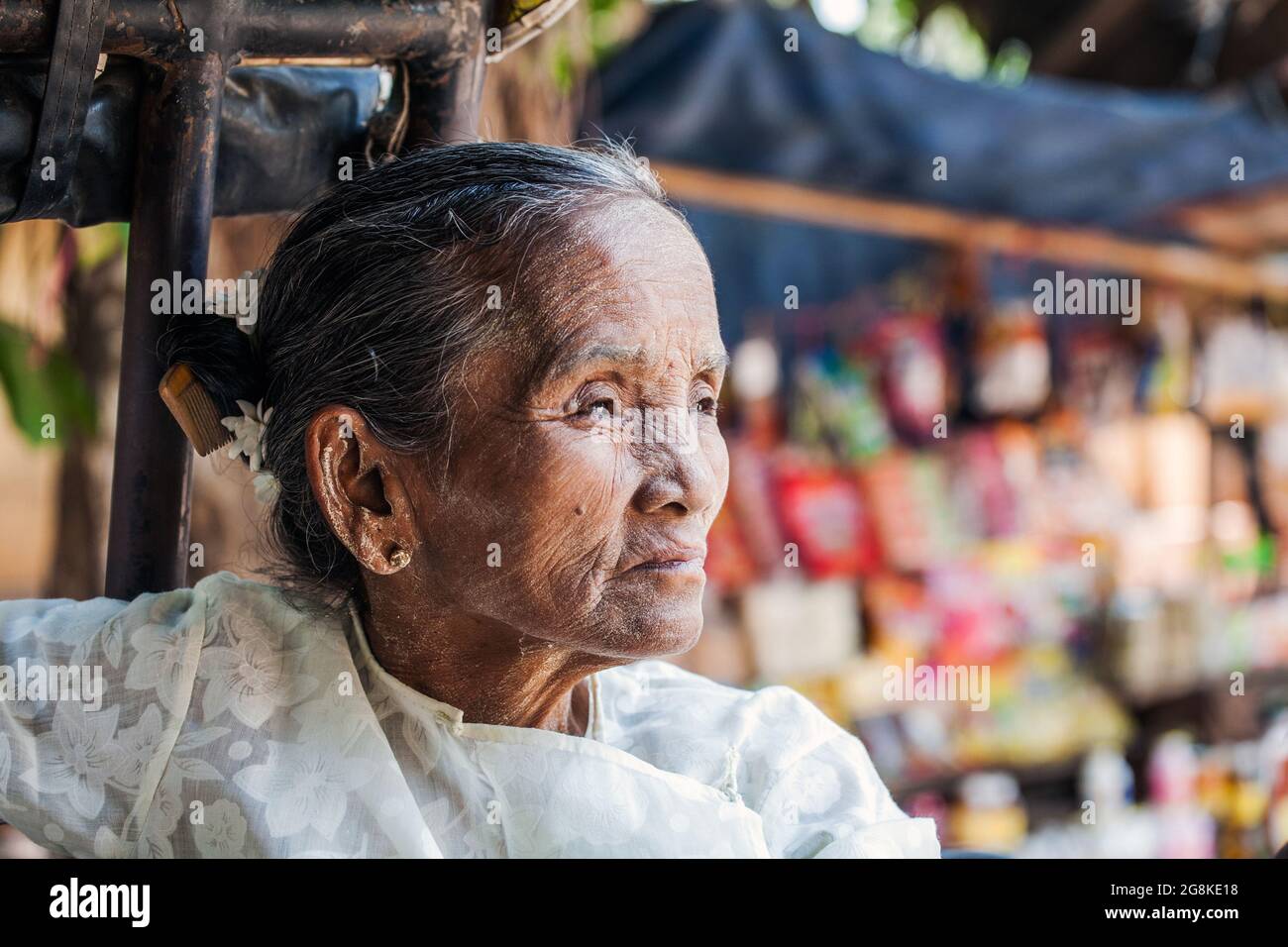 Profile of elderly Burmese lady on local bus with grey hair wearing ...