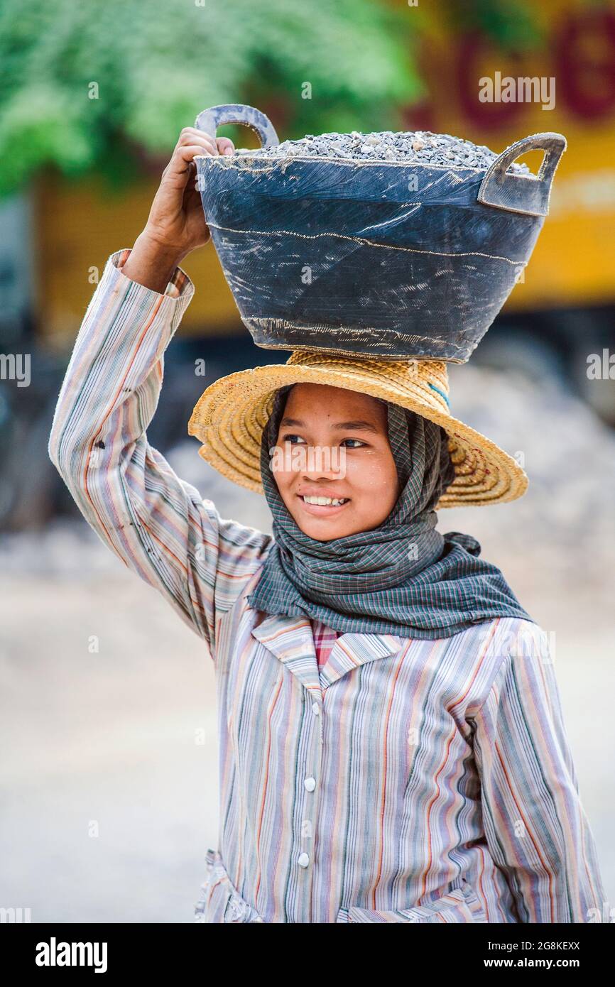 Young pretty Burmese child labourer road worker carrying basket of ...