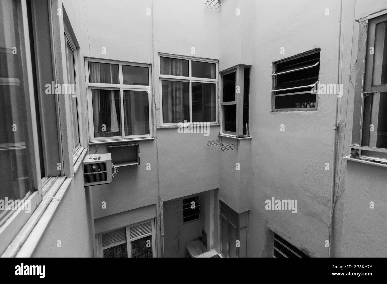 Grayscale shot of a backside of a building with closely located windows ...