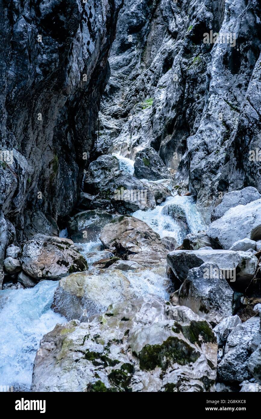 Scenic view of a river flowing among boulders and between rock cliffs ...