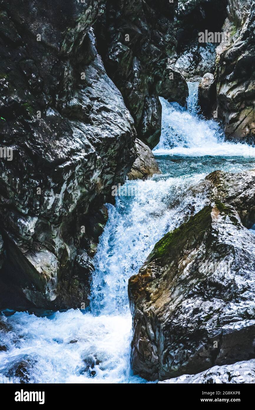 Scenic view of a river with several cascades flowing among boulders and ...