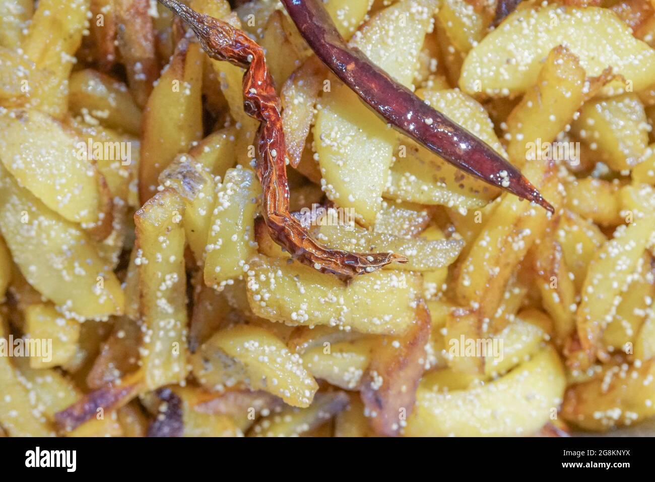 Close up image of fried potato pieces with fried red chilly - a fast ...