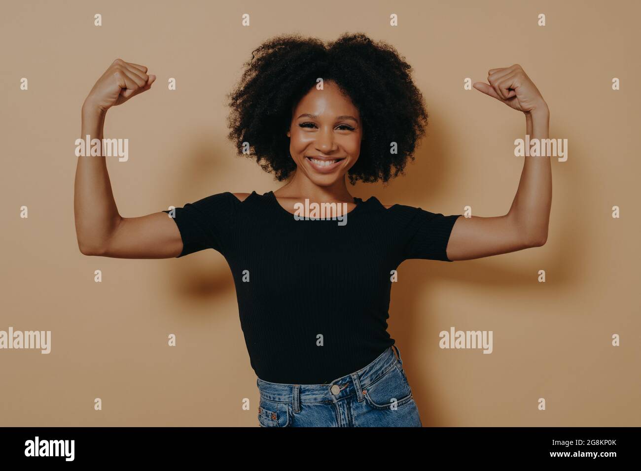 Young confident african lady in casual clothes showing strength of her ...