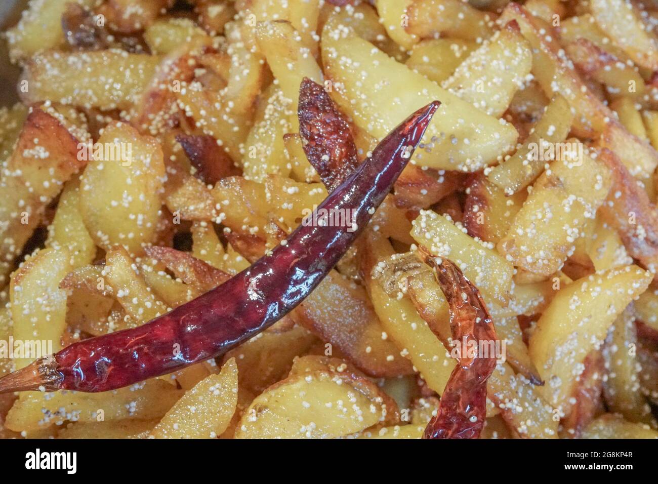 Close up image of fried potato pieces with fried red chilly - a fast ...