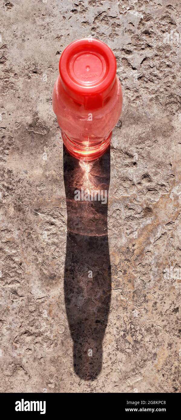 Vertical high angle shot of the shadow of a plastic water bottle ...