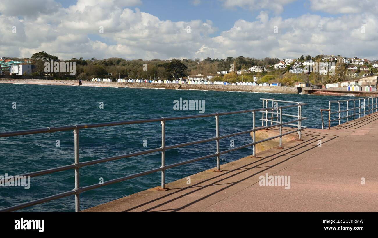 High tide at Goodrington Sands showing beach huts along the seafront ...