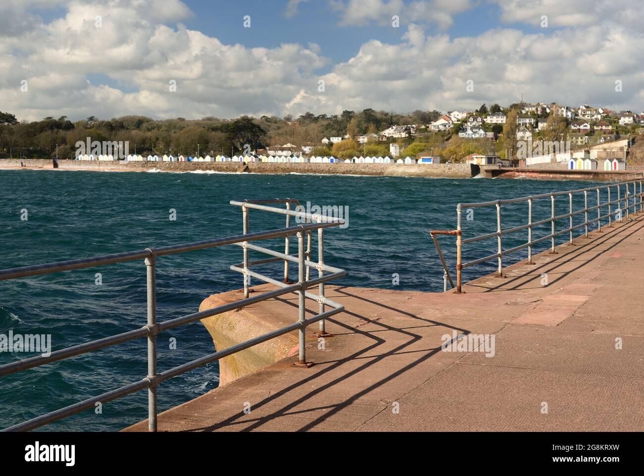 High tide at Goodrington Sands showing beach huts along the seafront ...